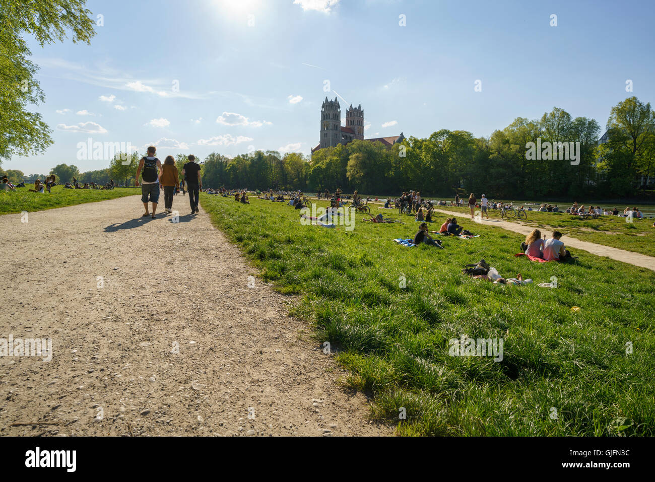 A busy summer day along the banks of the Isar river in Munich, Germany ...