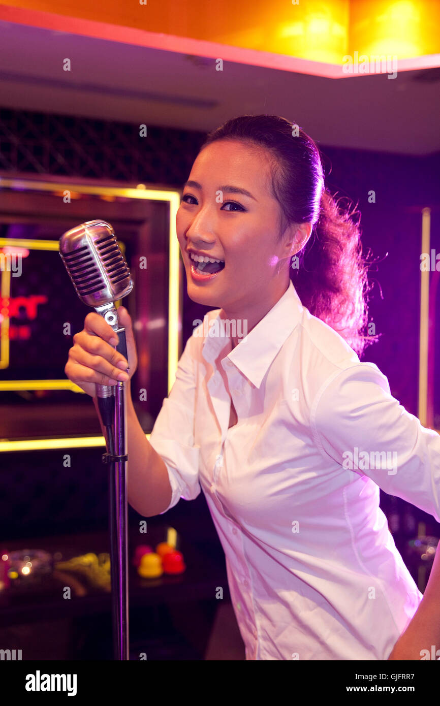 Young woman singing in KTV Stock Photo - Alamy