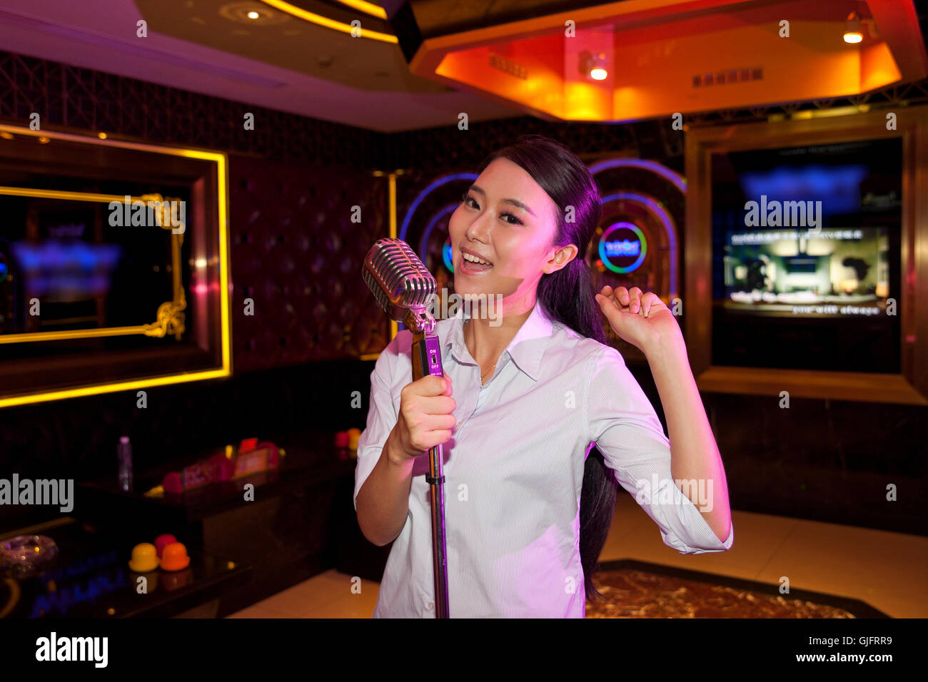 Young woman singing in KTV Stock Photo - Alamy