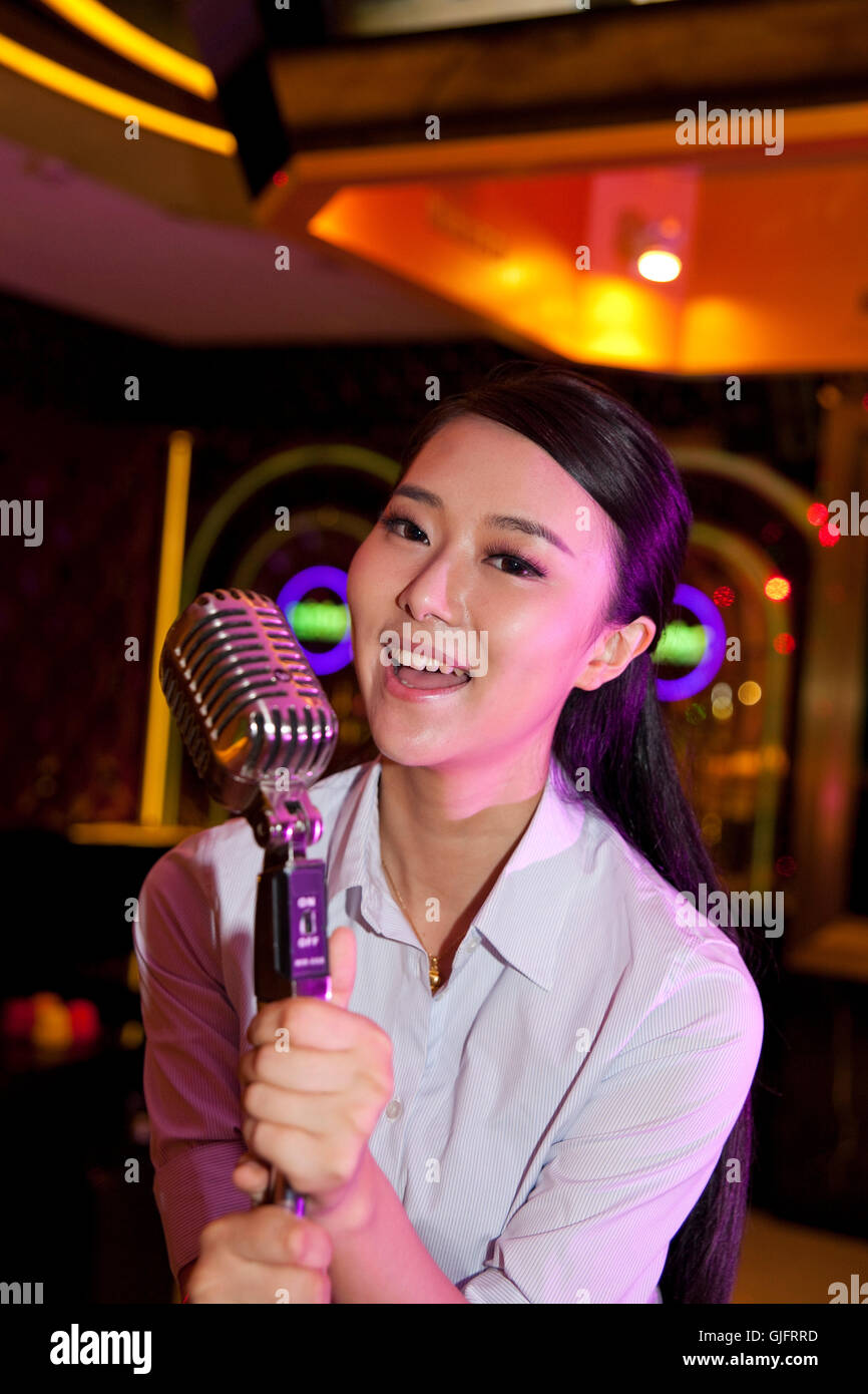 Young woman singing in KTV Stock Photo - Alamy