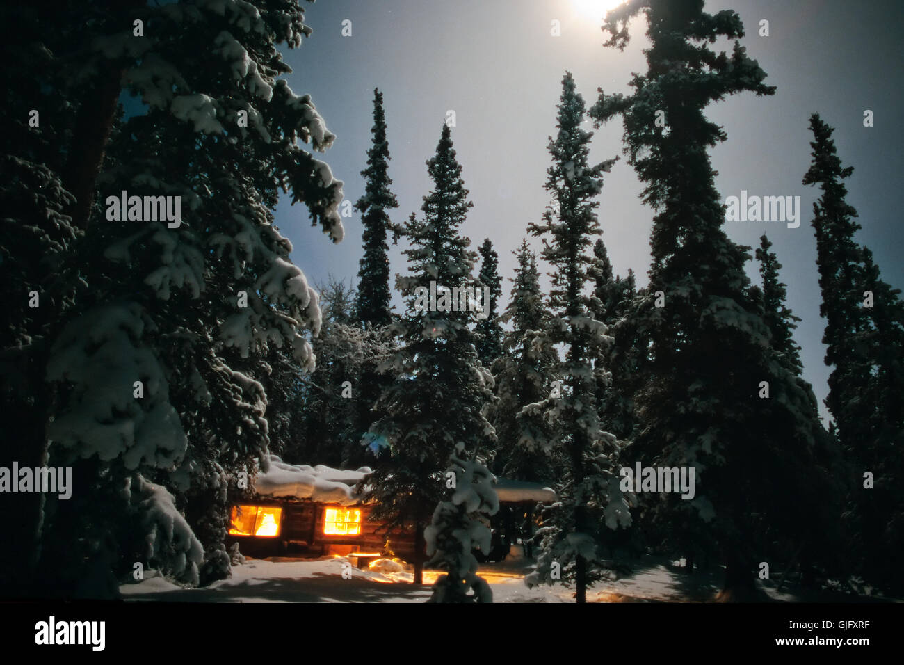 Cozy log cabin at moon-lit winter night Stock Photo - Alamy