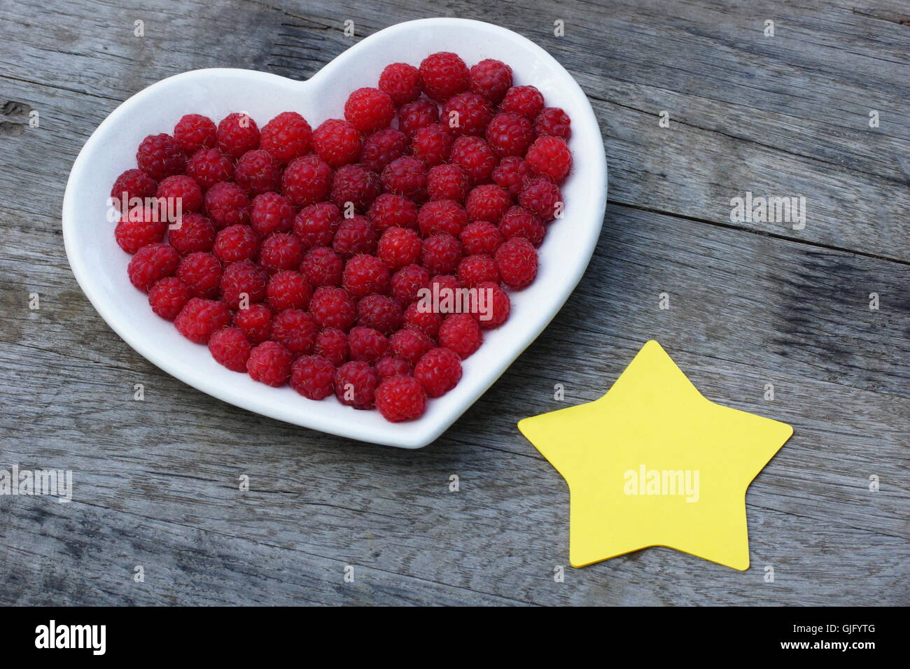 Red heart made of raspberry and yellow sticker Stock Photo - Alamy