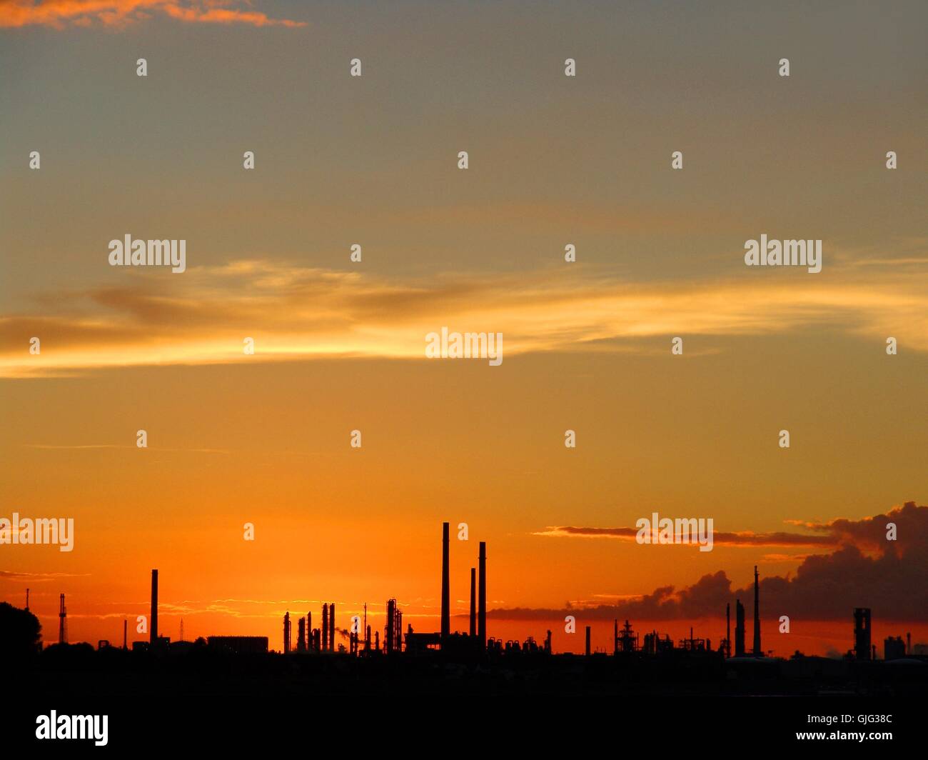 sun sets behind industrial plant Stock Photo - Alamy
