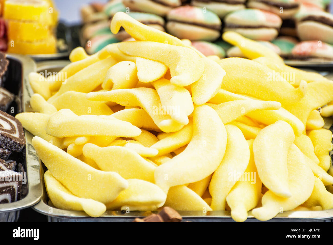 Yellow tasty licorice candies in plastic container. Sweet delight ...