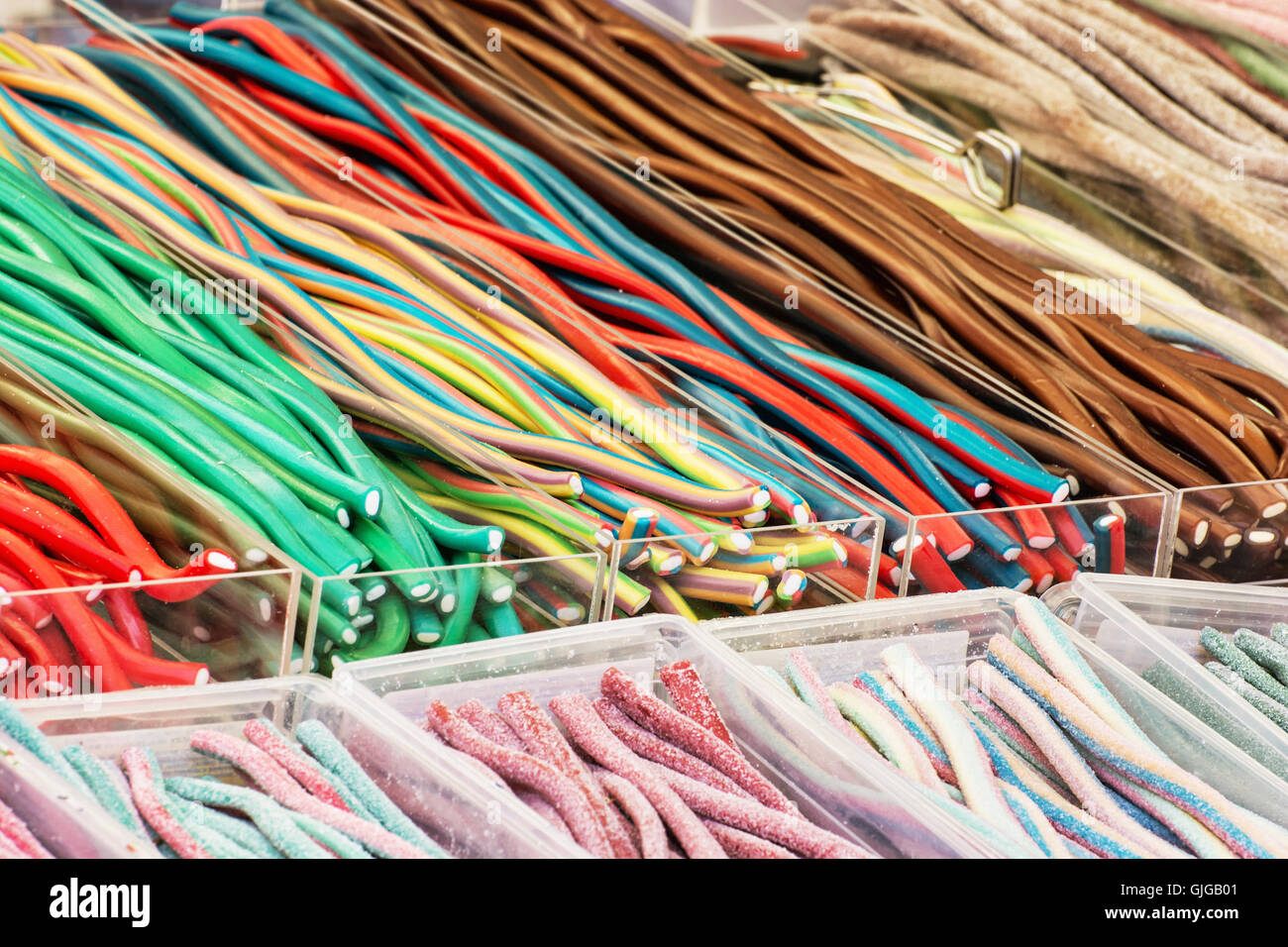 Colorful tasty licorice candies in plastic containers. Sweet delight ...