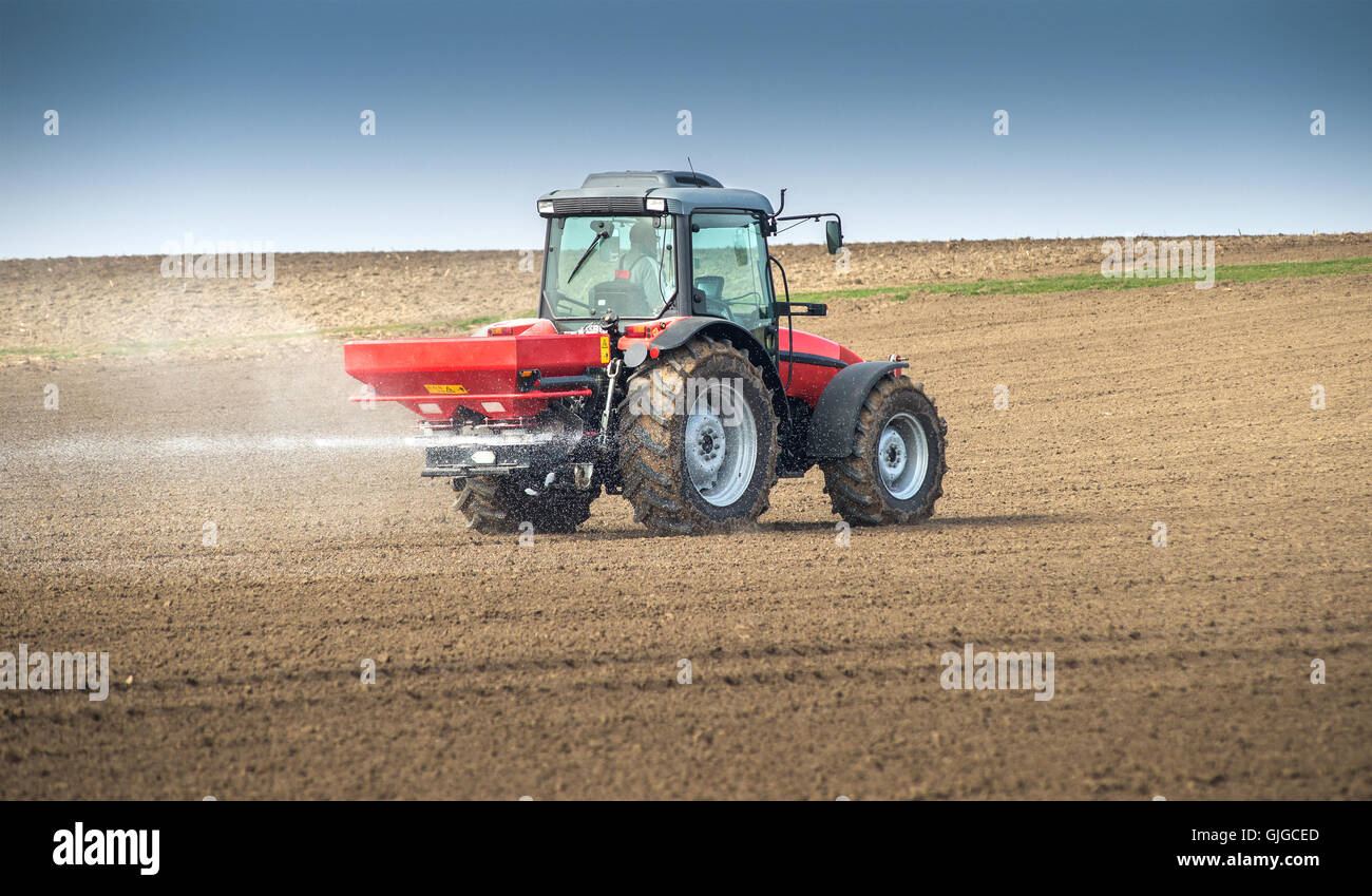 Tractor and fertilizer spreader in field Stock Photo - Alamy