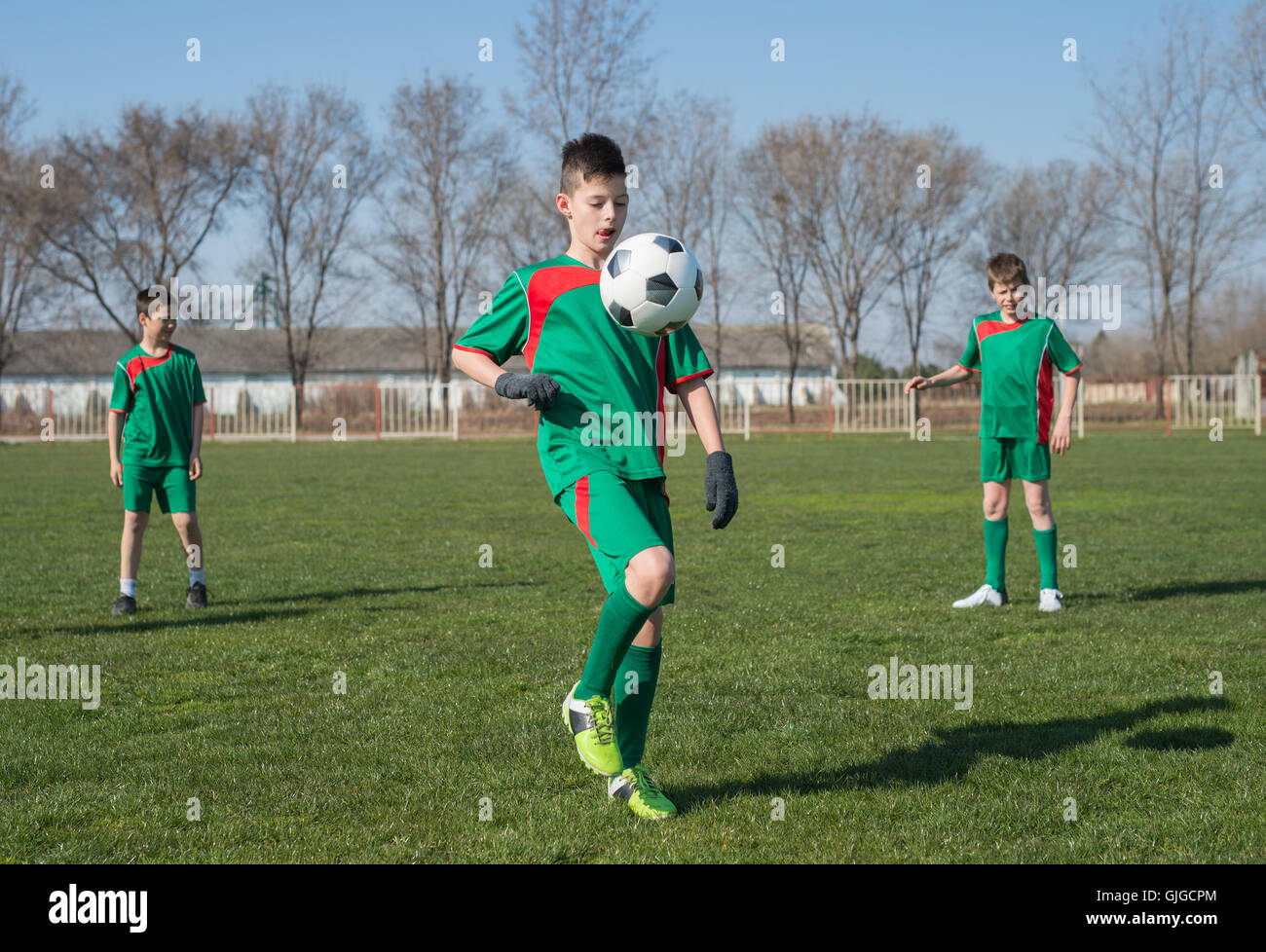 Boys kicking football on the sports field Stock Photo - Alamy