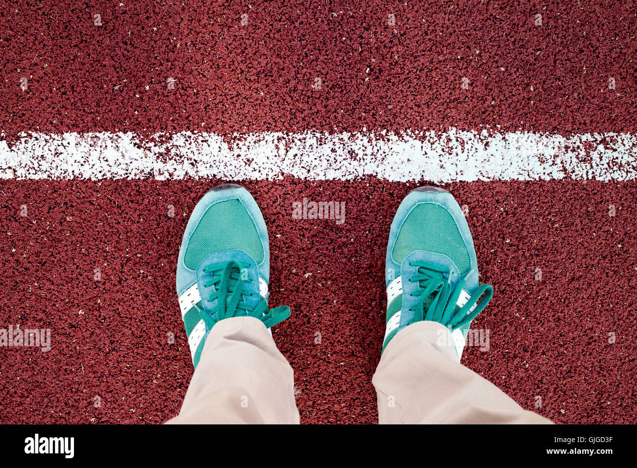 Feet are on the stadium track with a white stripe Stock Photo - Alamy