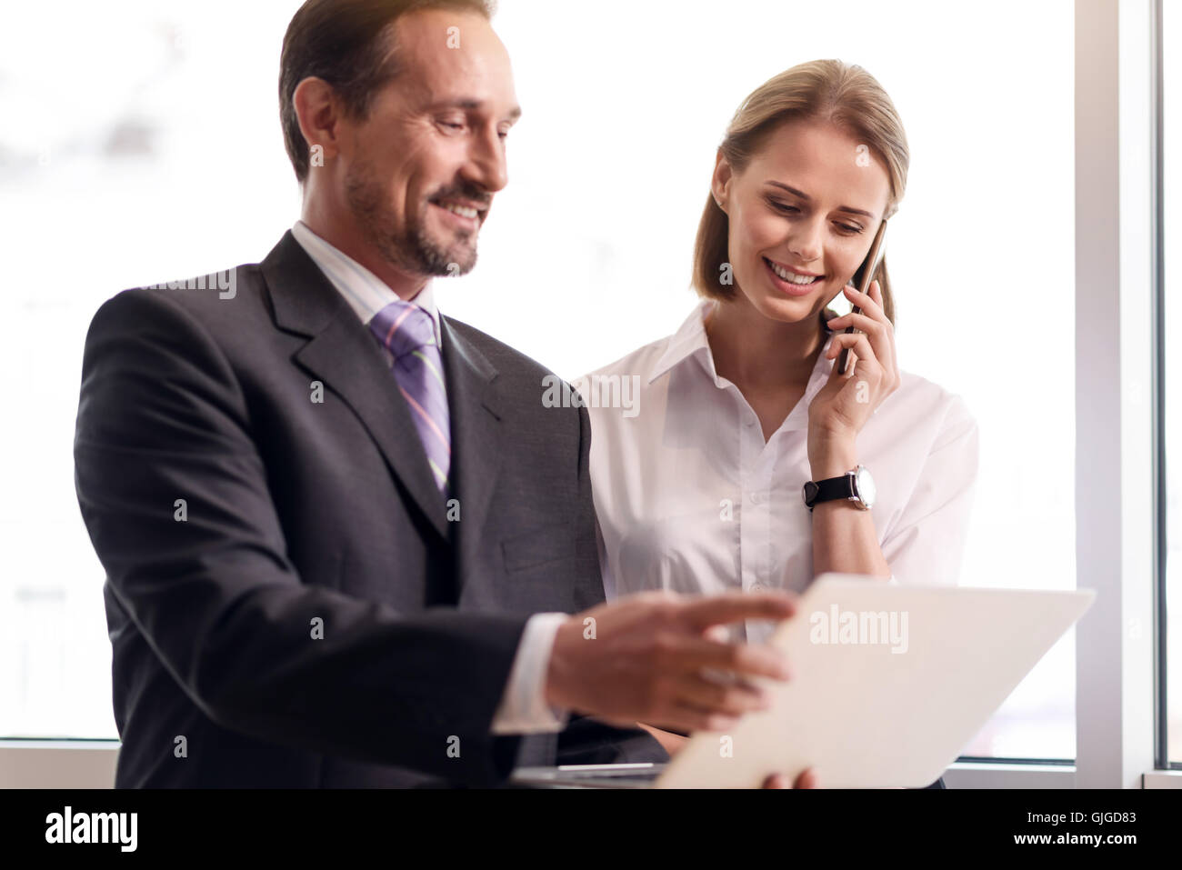 Positive colleagues standing in the office Stock Photo - Alamy