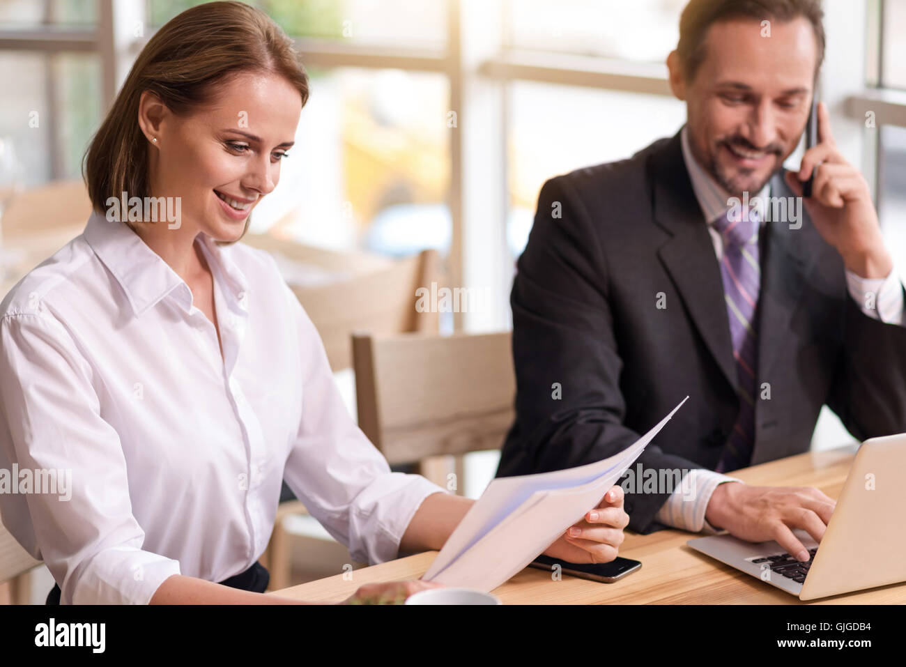 Positive colleagues sitting at the table Stock Photo - Alamy