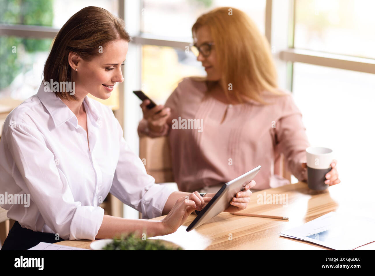 Delighted smiling woman using tablet Stock Photo - Alamy