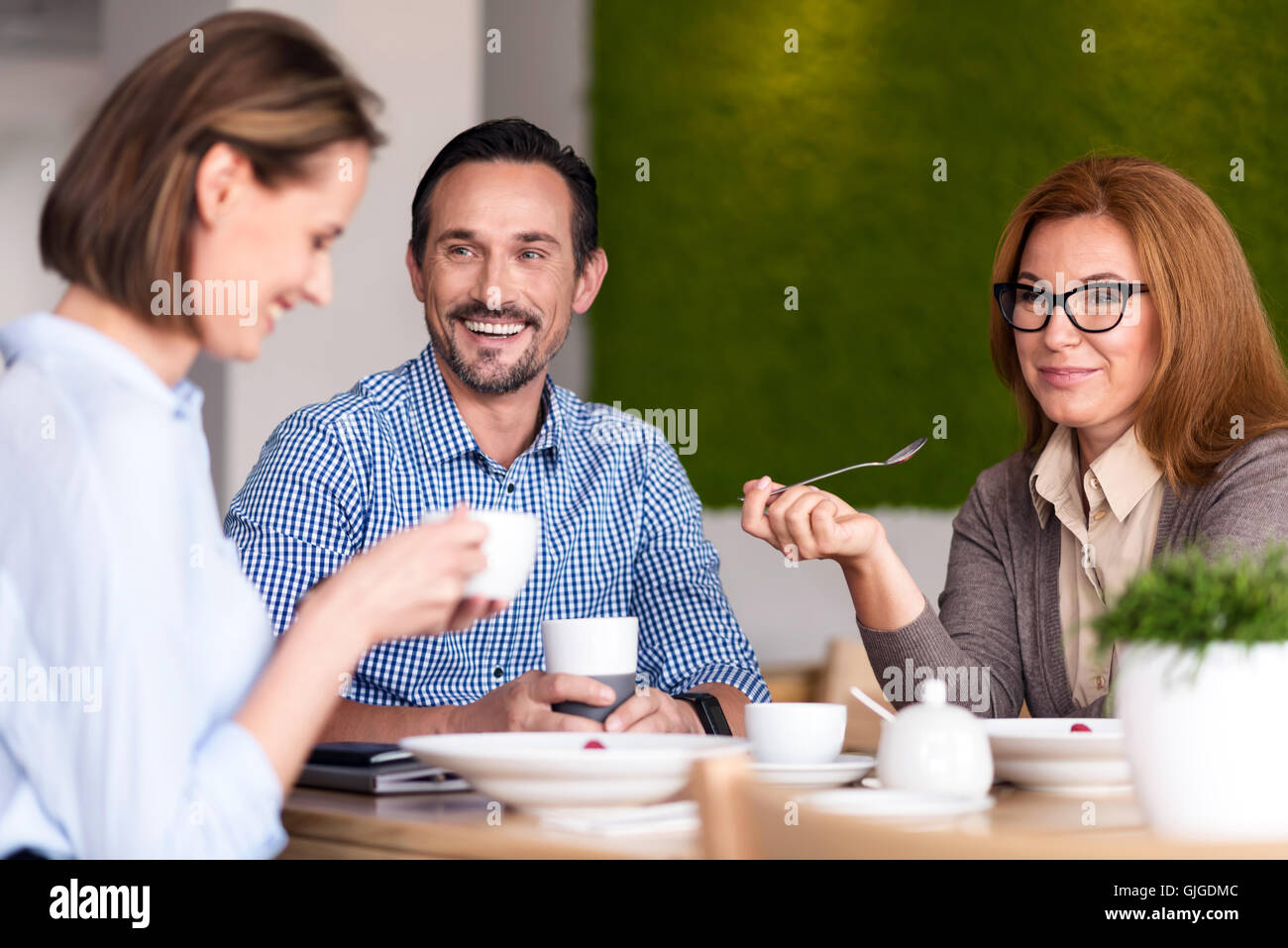Smiling colleagues having a lunch Stock Photo - Alamy