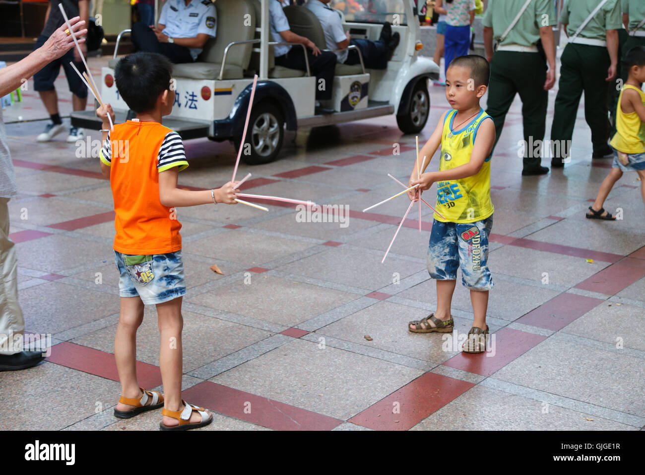Boys playing with imaginary sword made of straws at Huizhou shopping ...