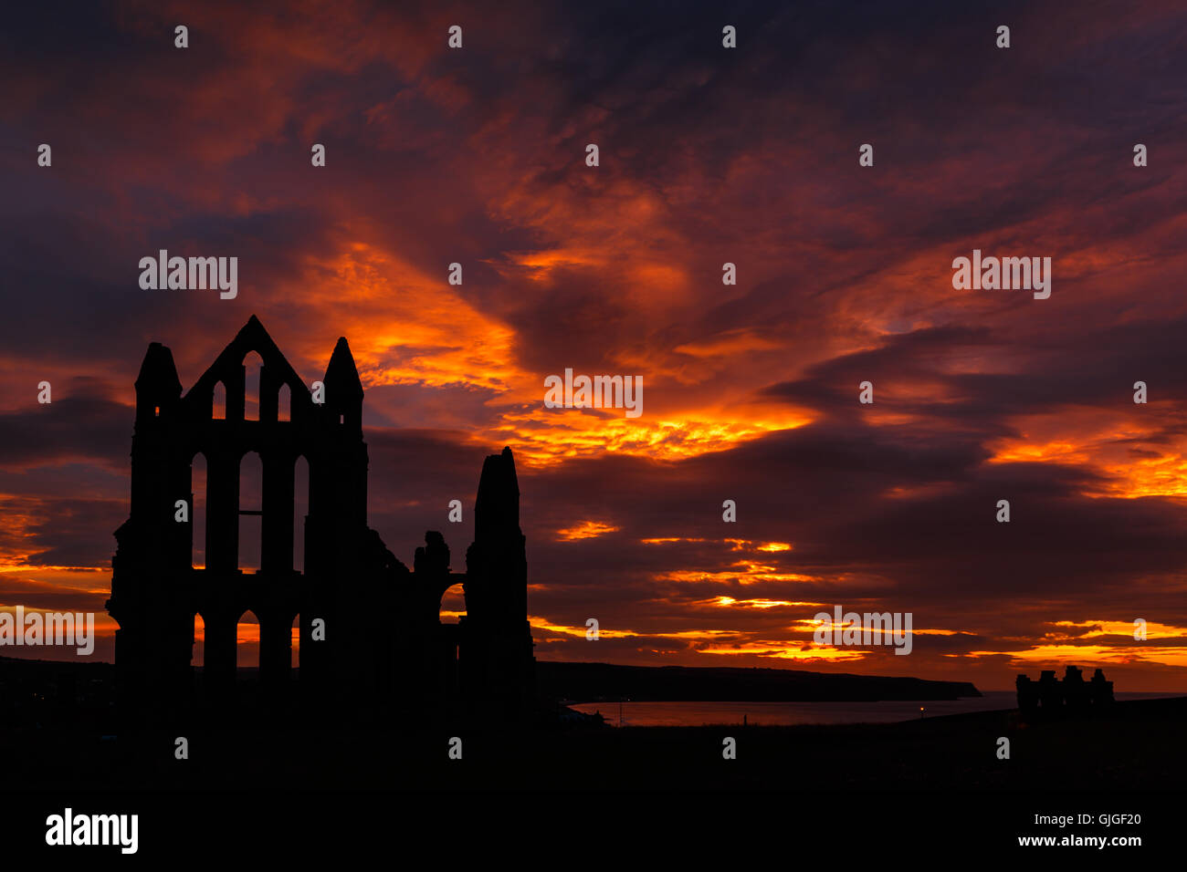 Whitby Abbey against a dramatic fiery sunset. In Whitby, North ...