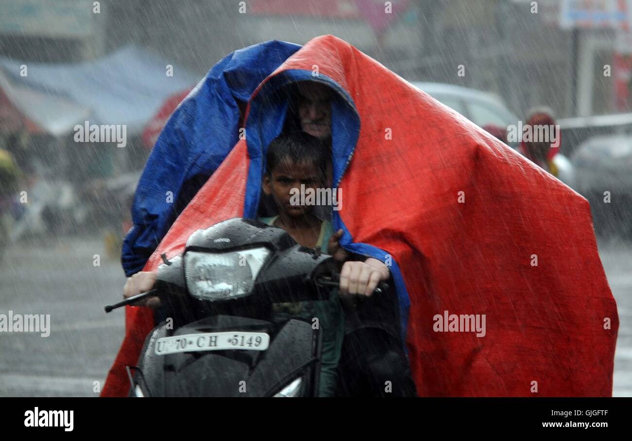 Allahabad, India. 16th Aug, 2016. Commuters use plastic sheet to be ...