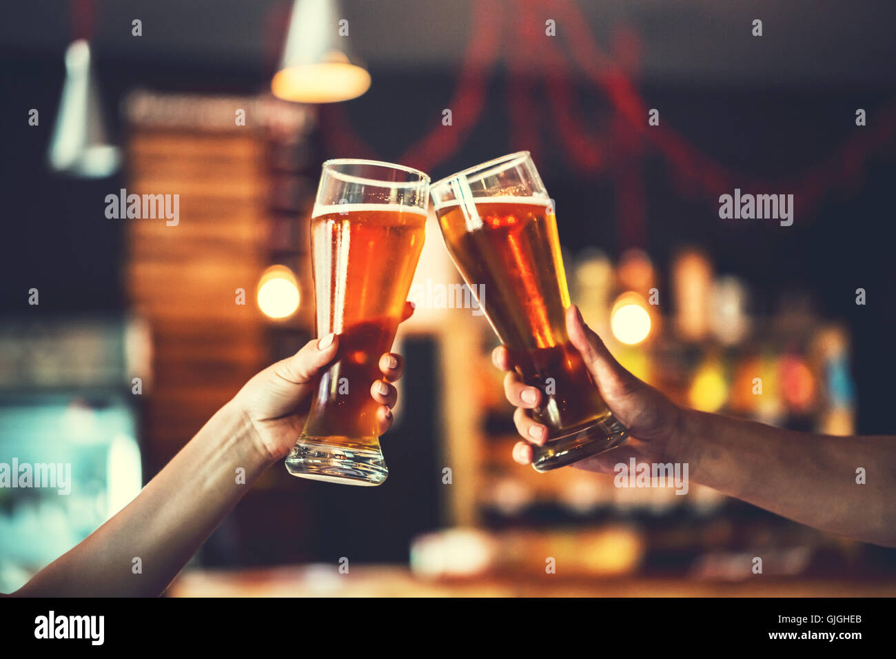 Two friends toasting with glasses of light beer at the pub. Beautiful ...