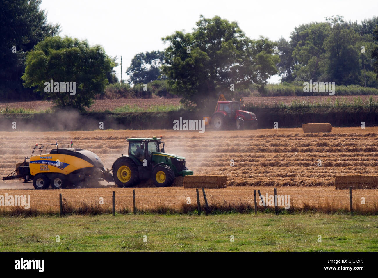 Tractor Bailing hay in the midday sun Stock Photo - Alamy