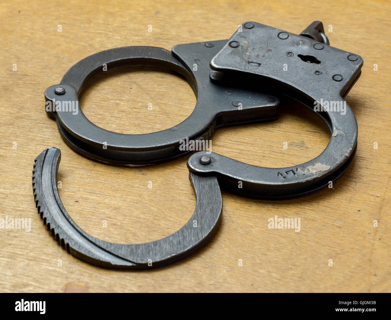 Handcuffs, Security concept on wooden background Stock Photo - Alamy