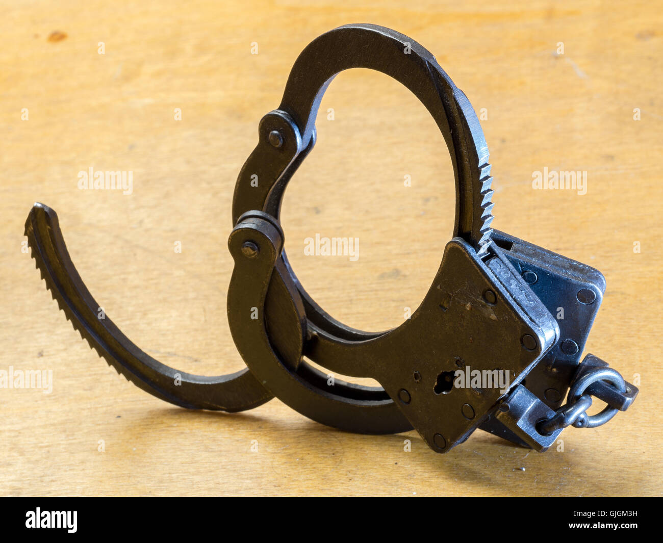 Handcuffs, Security concept on wooden background Stock Photo - Alamy