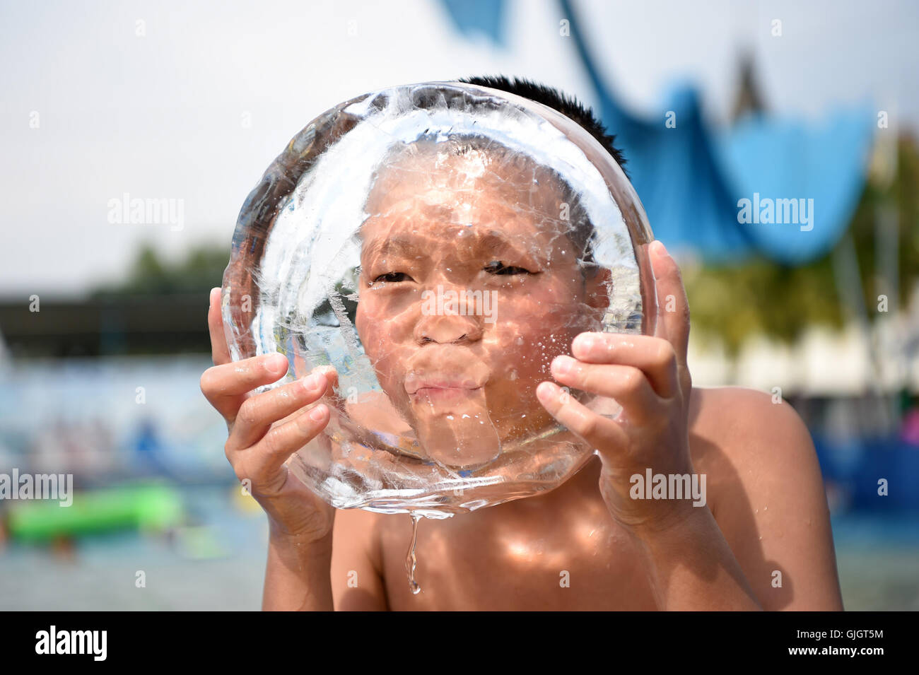 Chongqing. 16th Aug, 2016. A boy uses ice to cool off in southwest ...