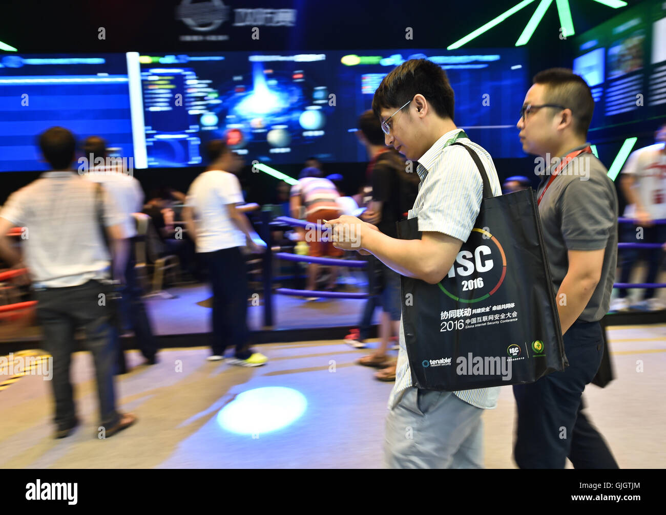 Beijing, China. 16th Aug, 2016. Guests walk past the exhibition area of ...