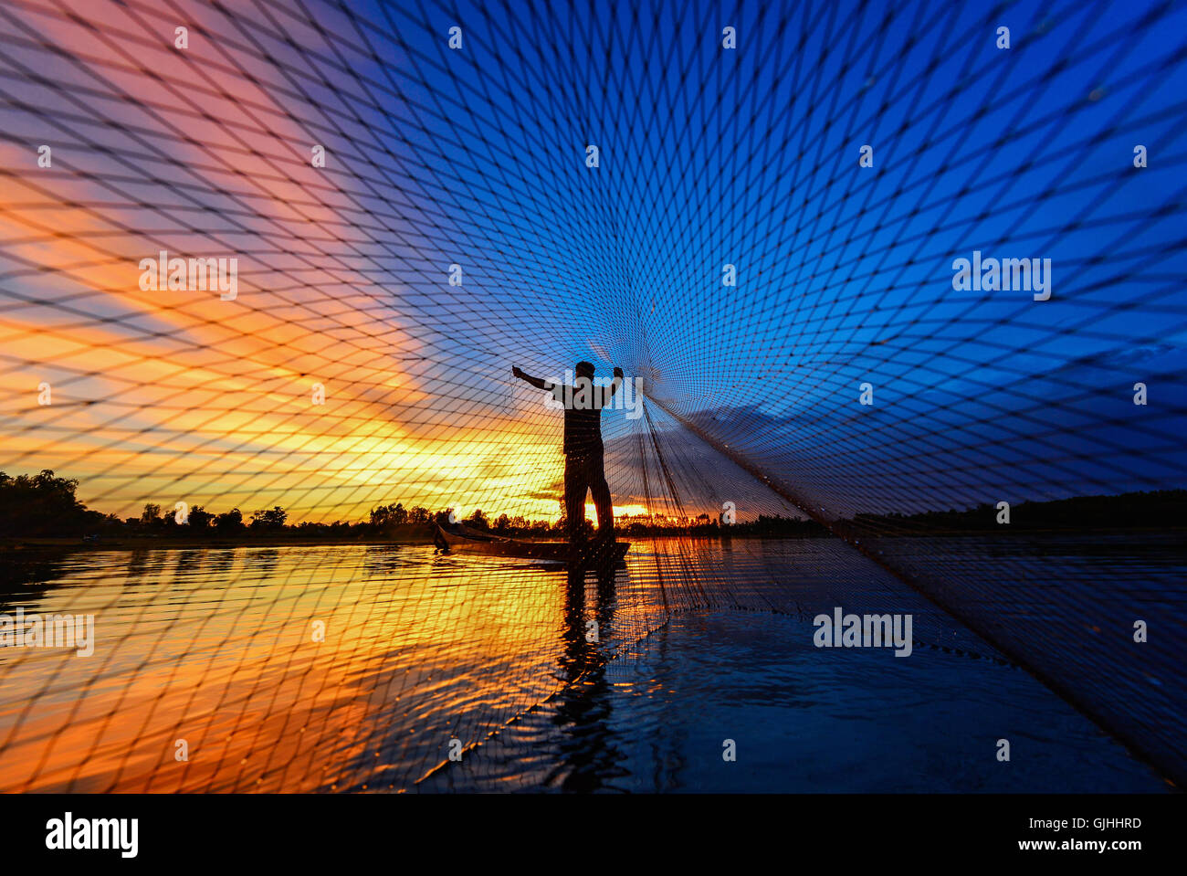 Fisherman casting fishing net at sunset, Thailand Stock Photo - Alamy