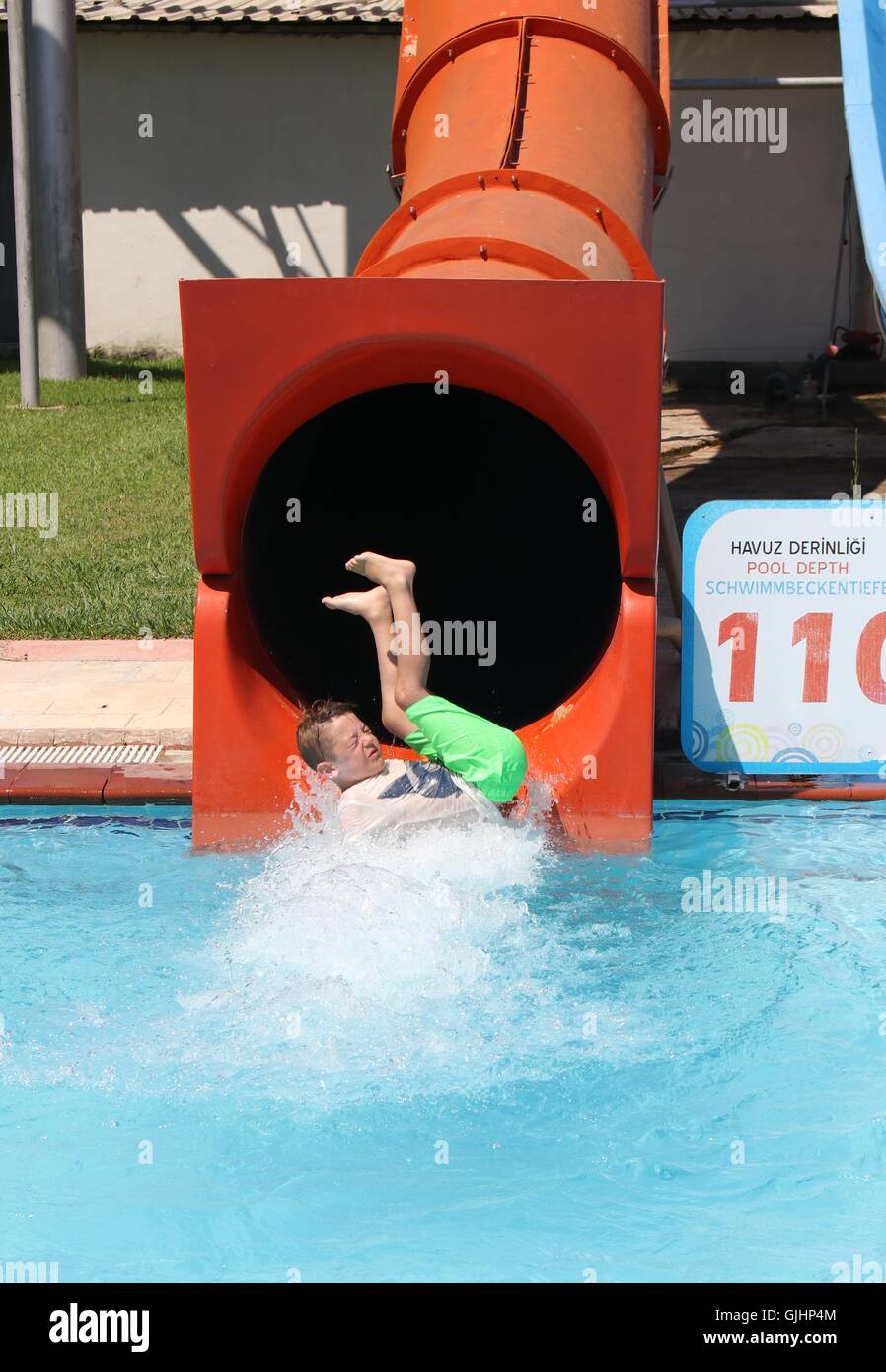 A young English boy having fun on a water slide in a waterpark while on ...
