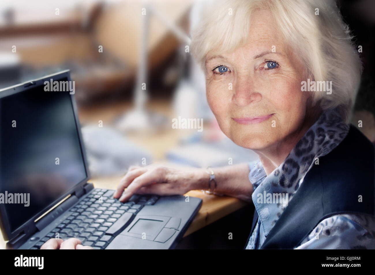 Senior woman smiles laptop hi-res stock photography and images - Alamy