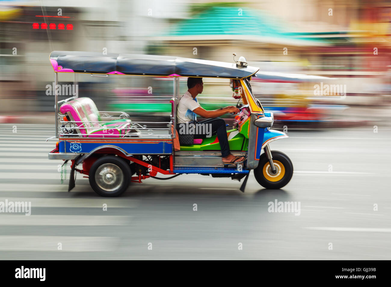 traditional tuktuk drives on a road in Bangkok, Thailand, shown in motion blur Stock Photo - Alamy