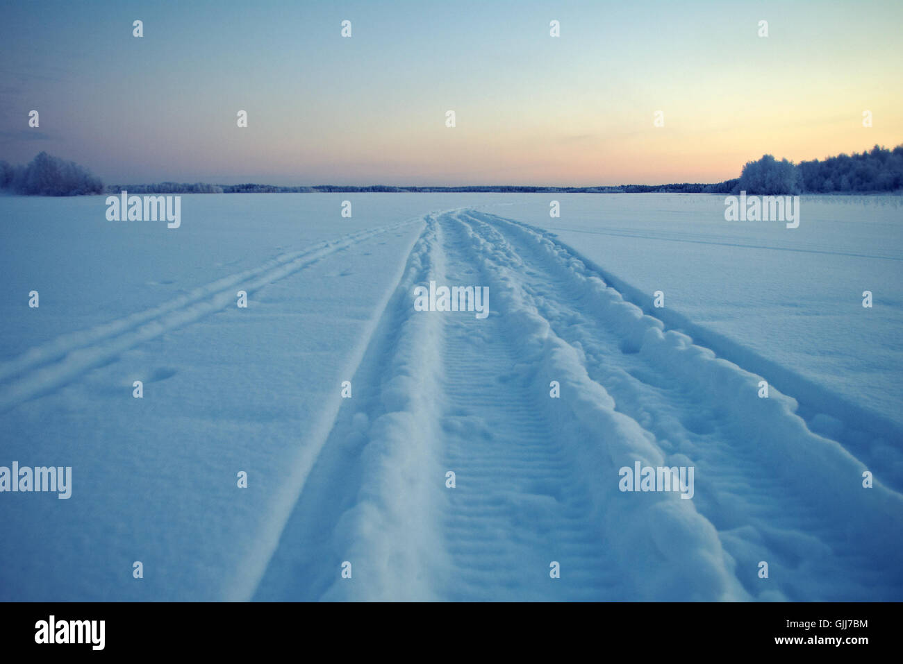Winter landscape.trace of a snowmobile on frozen lake Stock Photo - Alamy