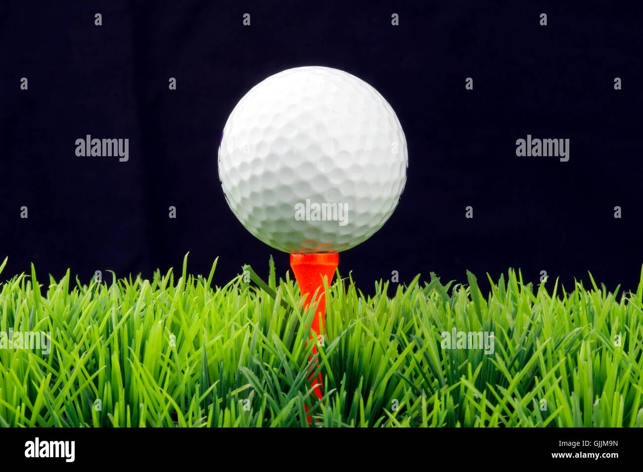 golf ball on a red tea Stock Photo - Alamy