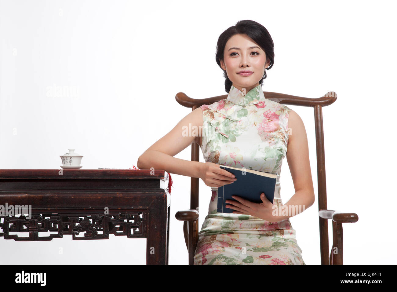 Dressed in traditional Chinese costumes studio shot young woman reading ...