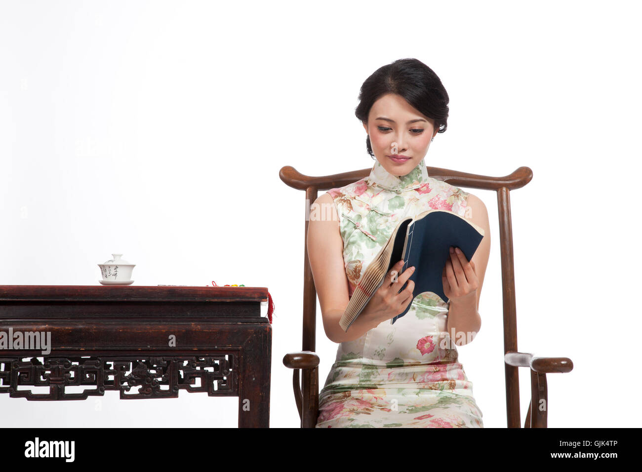 Dressed in traditional Chinese costumes studio shot young woman reading ...