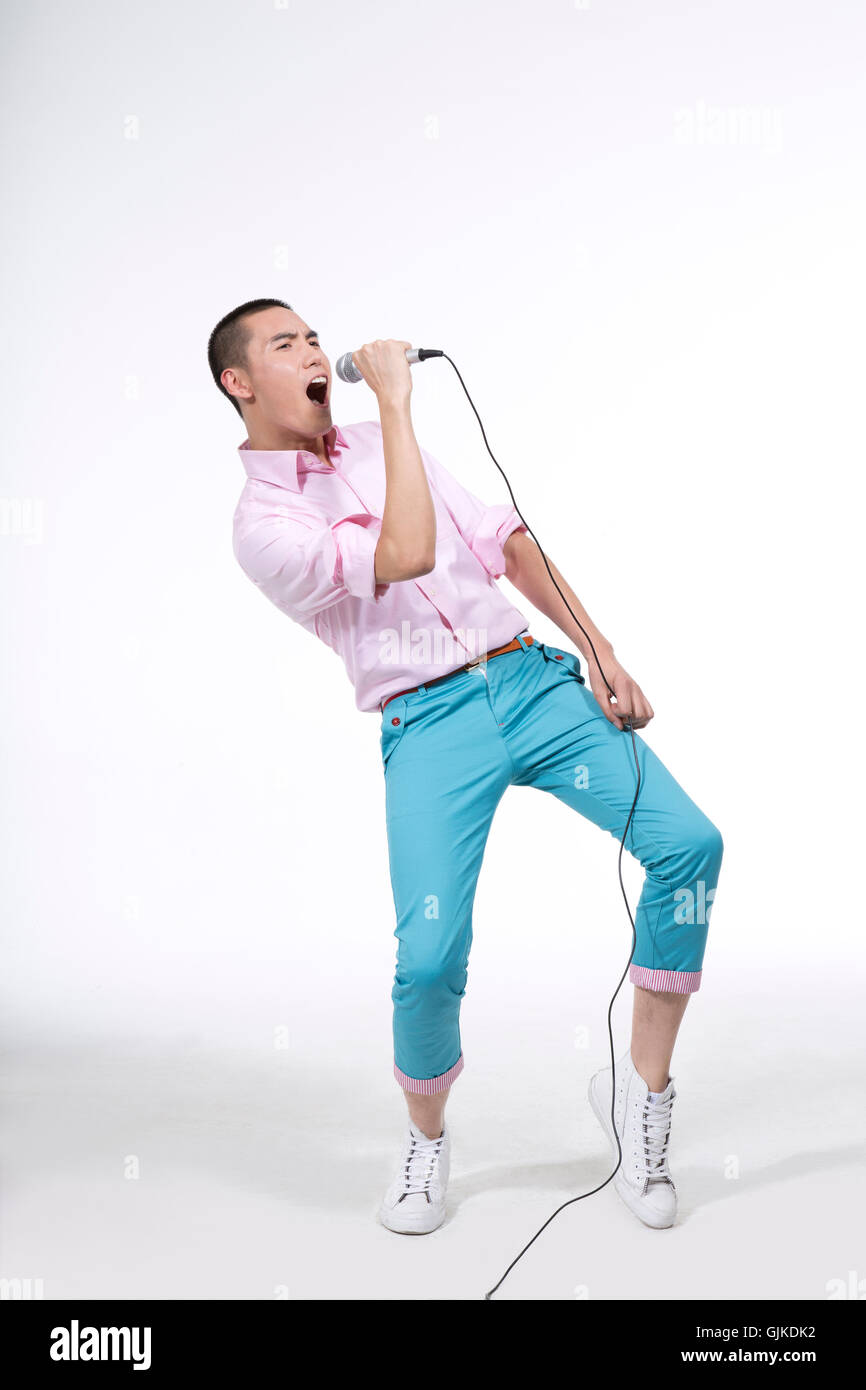 Studio shot Young casual man singing Stock Photo - Alamy