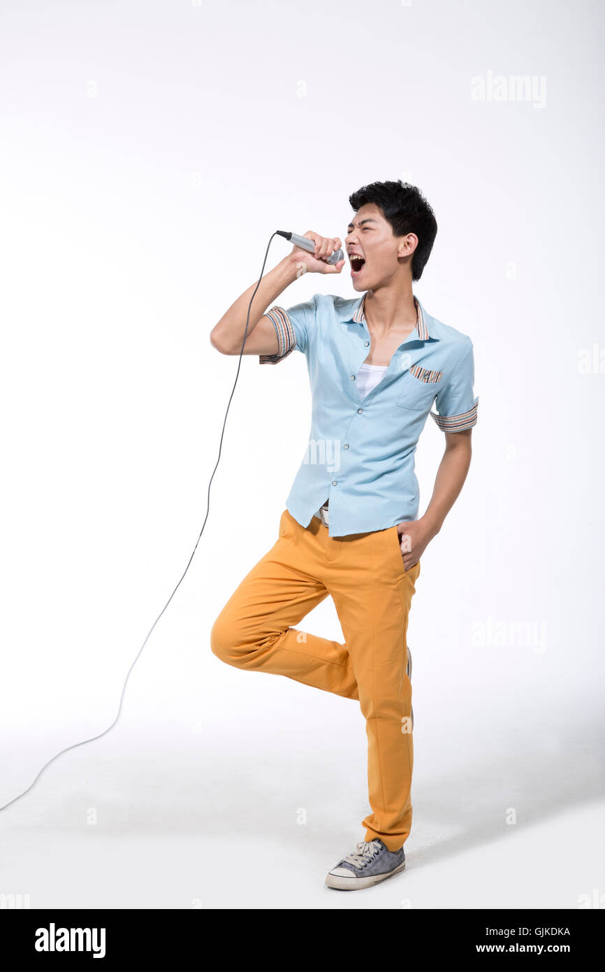 Studio shot Young casual man singing Stock Photo - Alamy