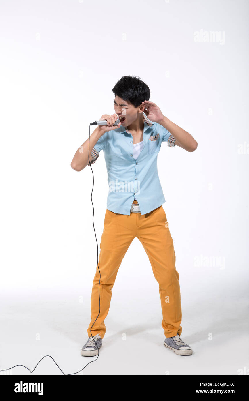 Studio shot Young casual man singing Stock Photo - Alamy