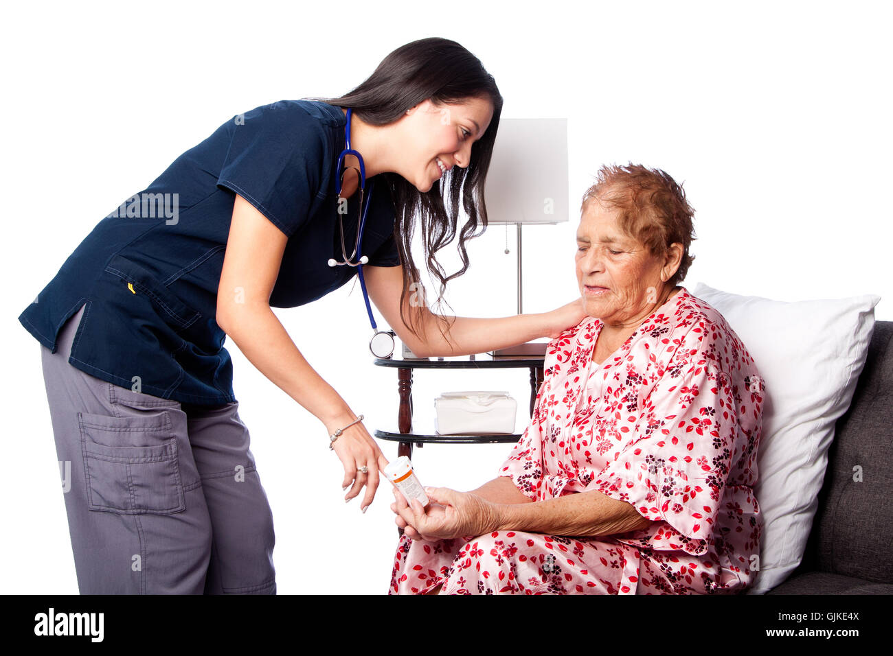 Nurse explaining prescription medication to senior patient, home ...