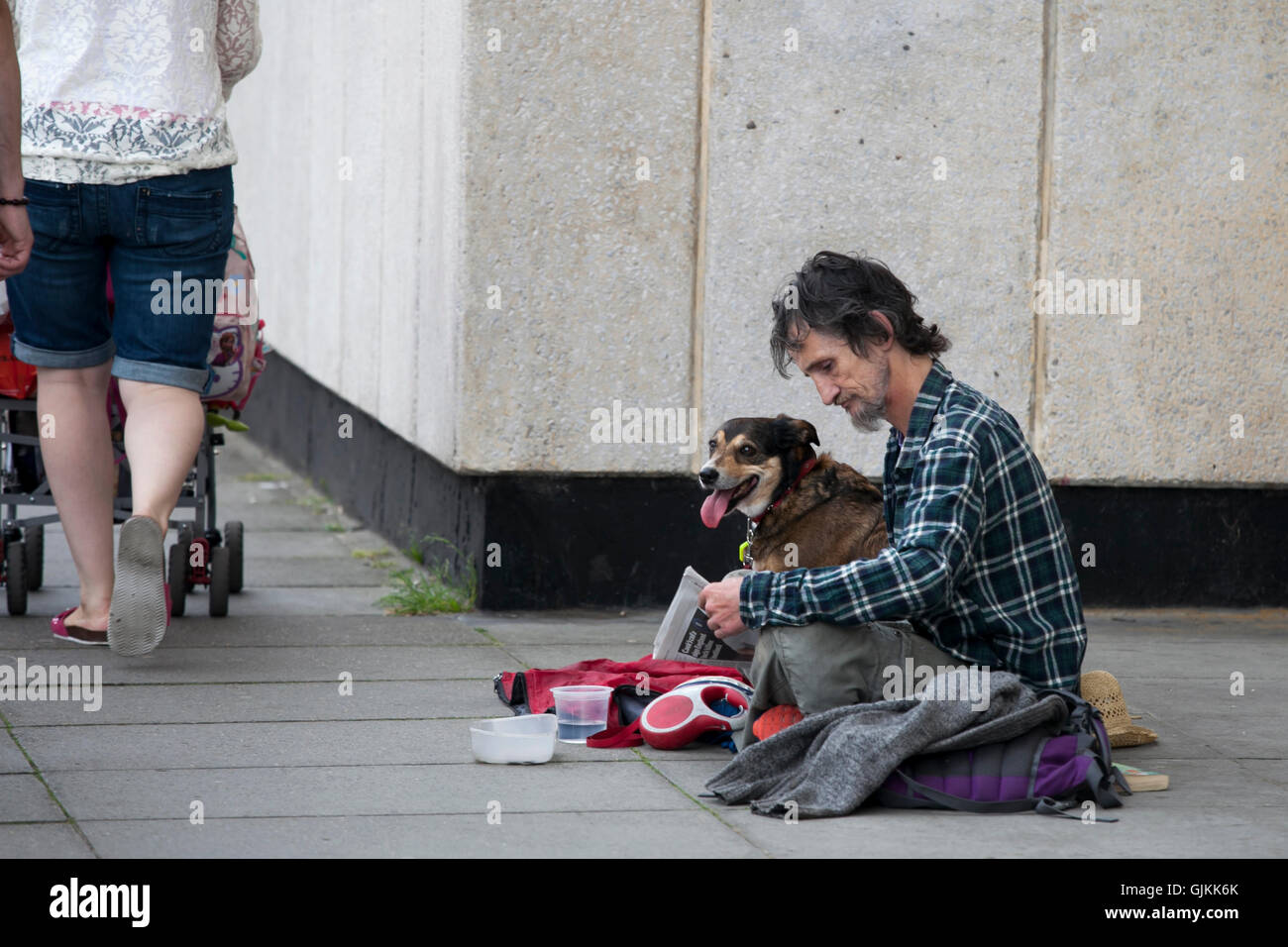 a poor man with a dog begging on the street Stock Photo - Alamy