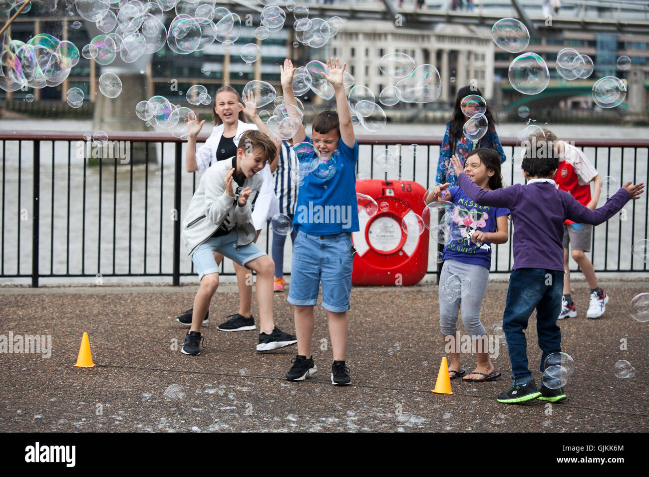 Children catch soap bubbles near Tate Modern in London UK Stock Photo ...