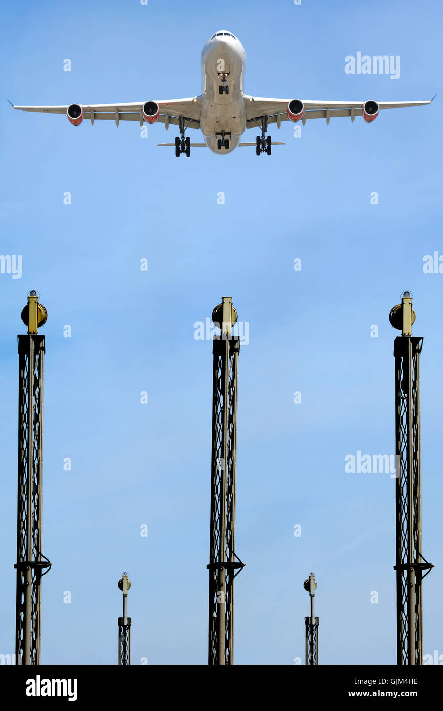Plane over lights in airport Stock Photo - Alamy