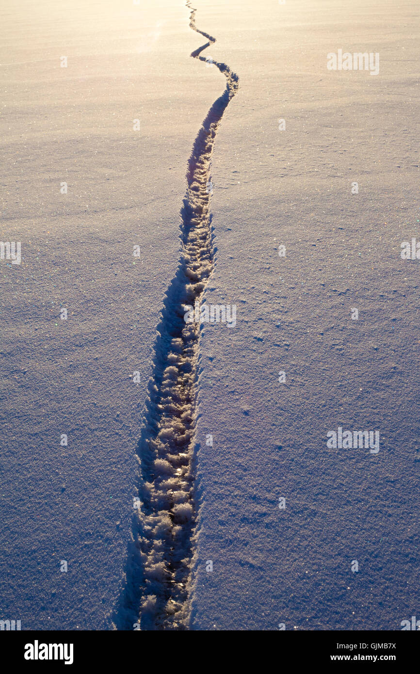 Wide crack in snow and ice surface Stock Photo - Alamy