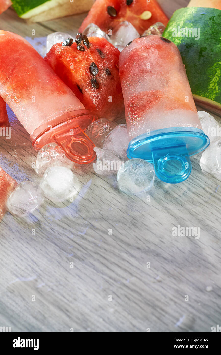Frozen watermelon popsicles with ice cubes and watermelon slices on ...