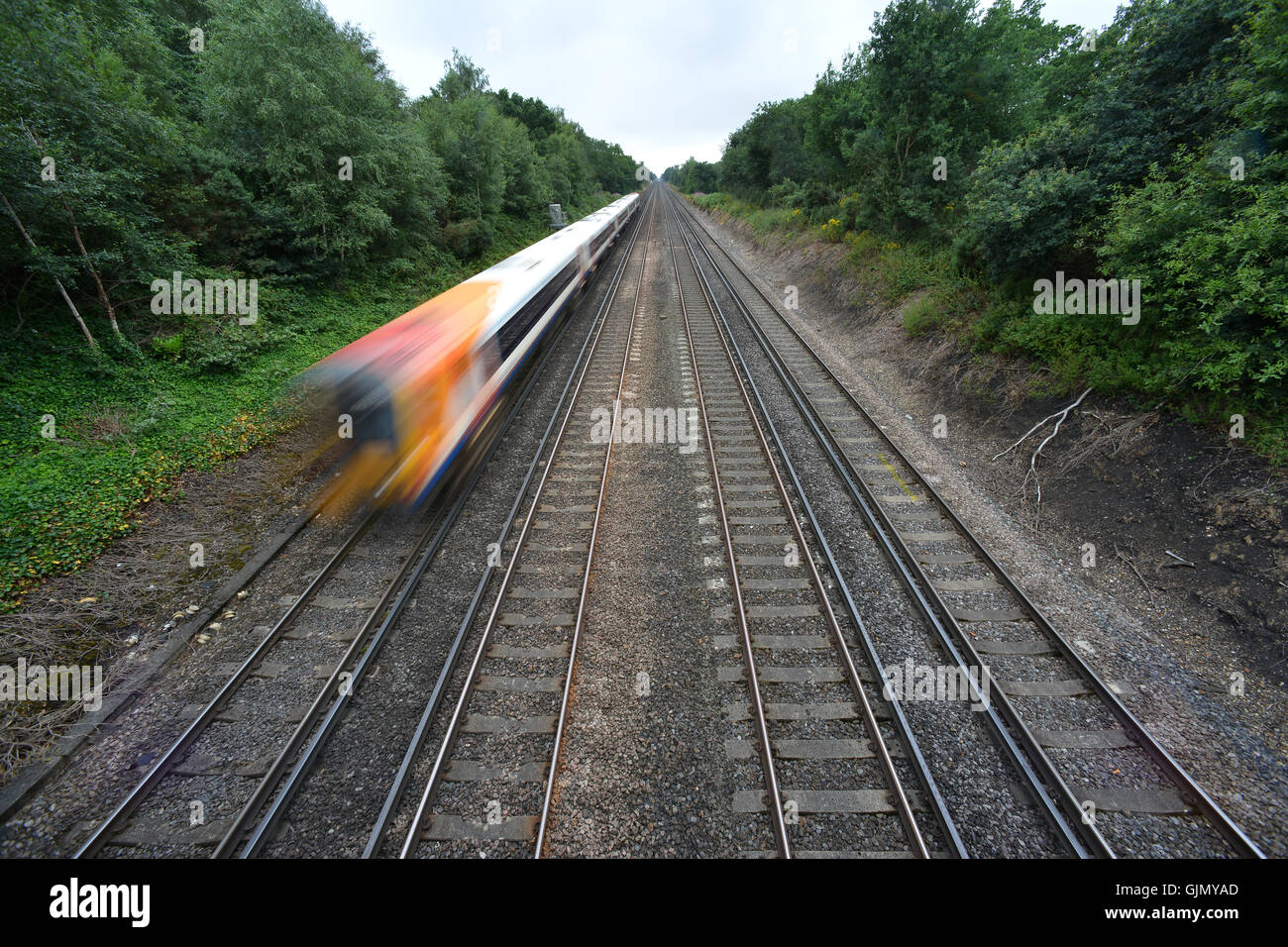 South West Train speeding on log straight track Stock Photo - Alamy