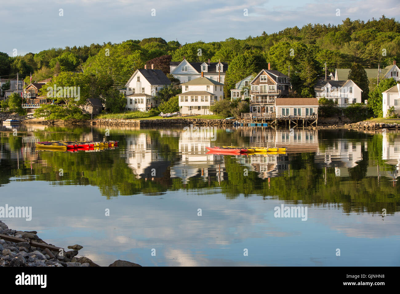 Reflections of homes and colorful Kayaks on Boothbay harbor, Maine ...