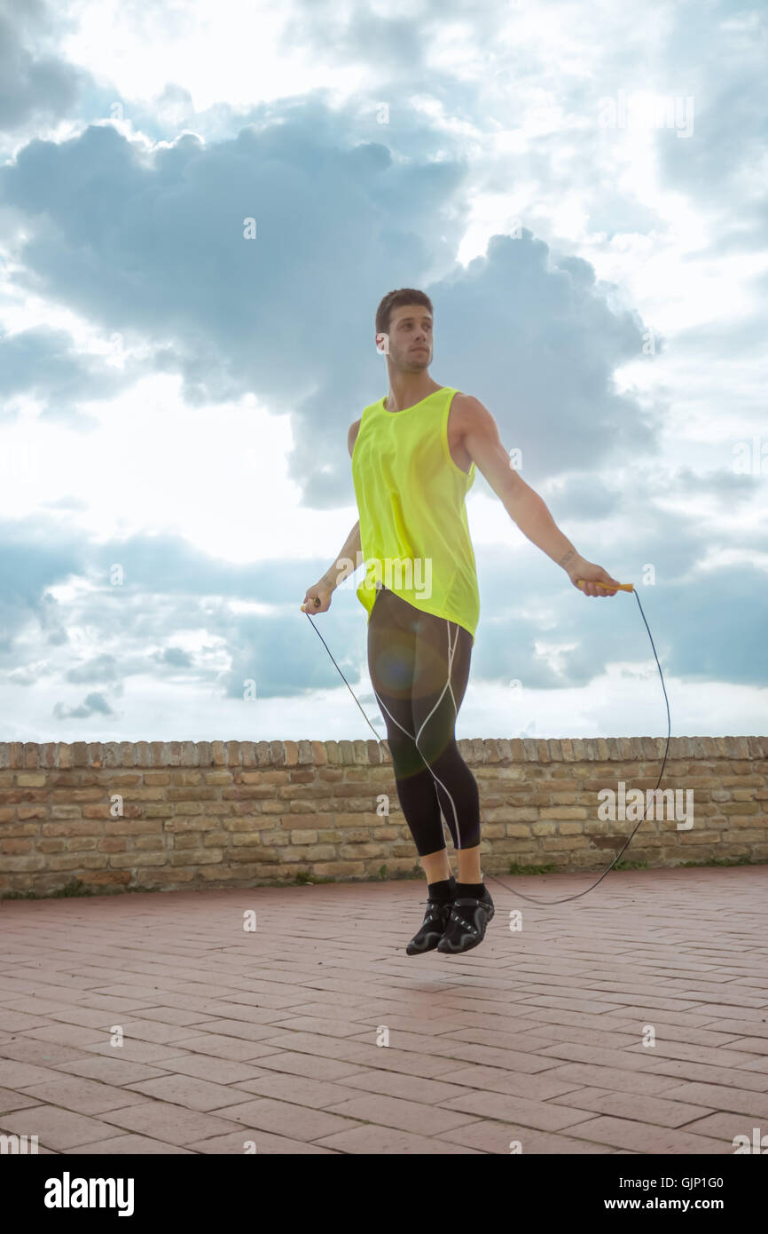 Young man jumping rope sky sunny day lens flare Stock Photo - Alamy