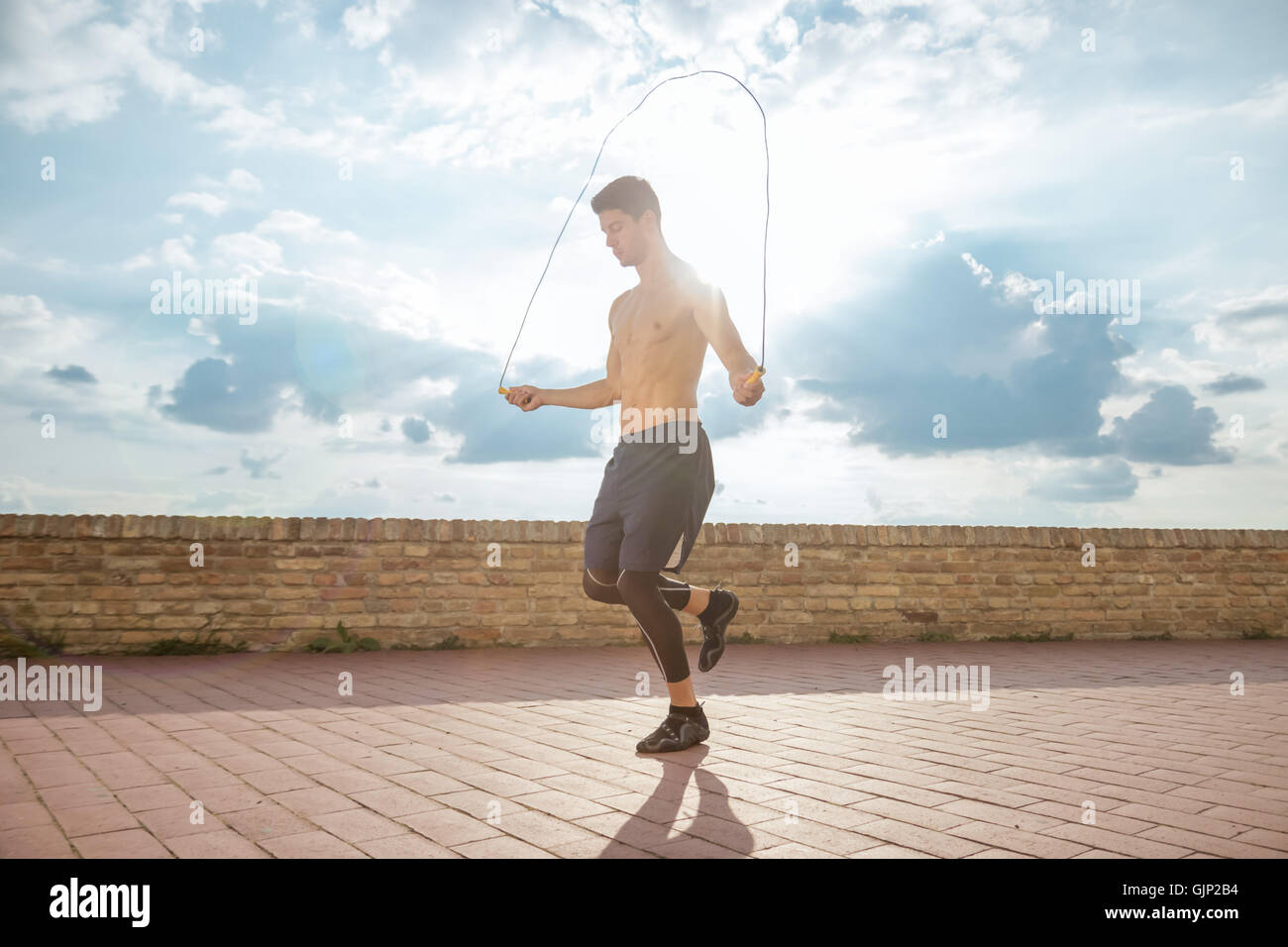 young man shirtless abs fit jumping rope outdoors sky sunny Stock Photo ...
