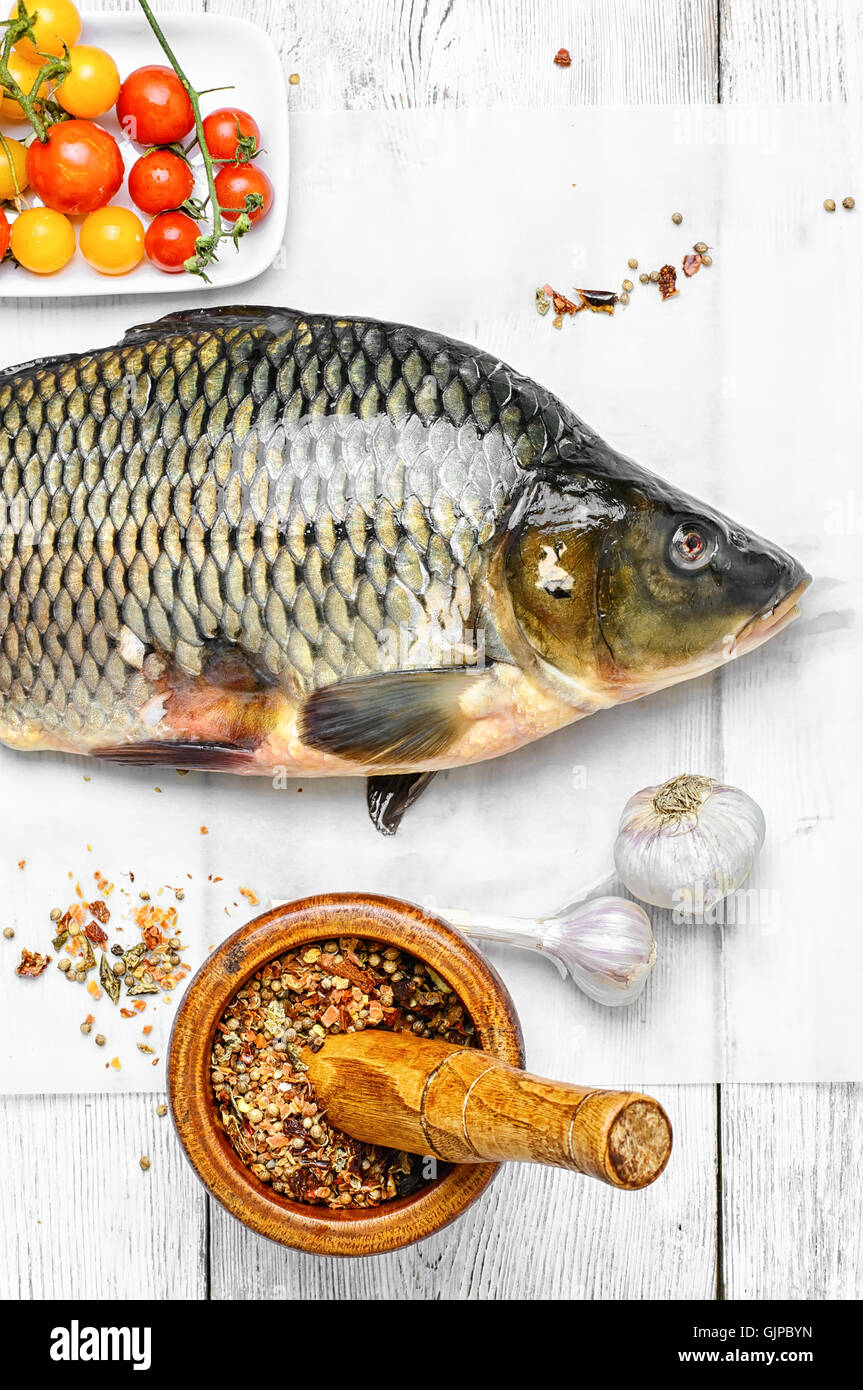 Raw carp on kitchen table and mortar with spices for fish Stock Photo ...