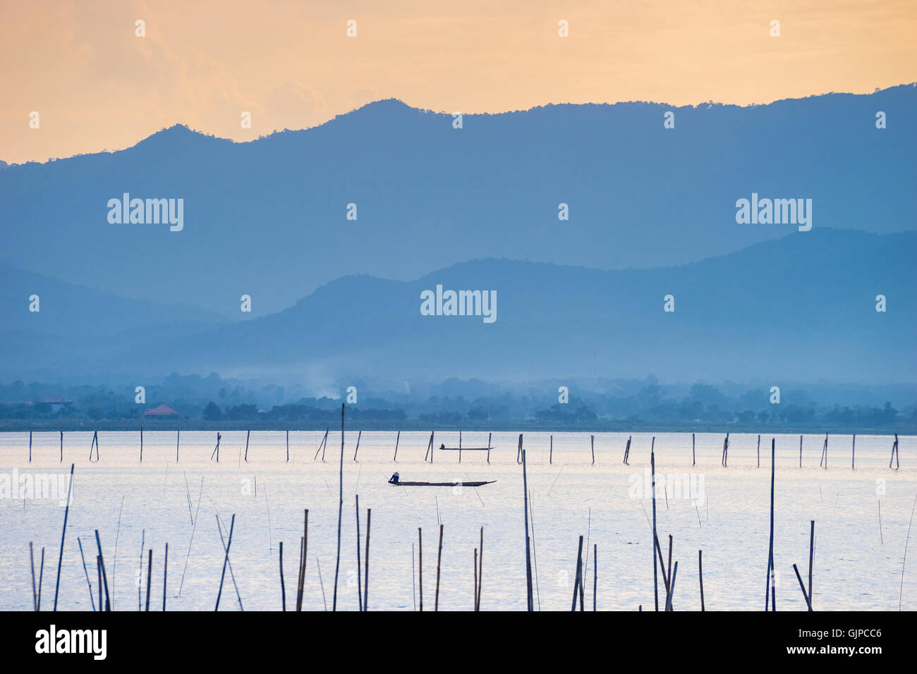 Golden hour sunset landscape with fisherman and boat on the lake Stock ...