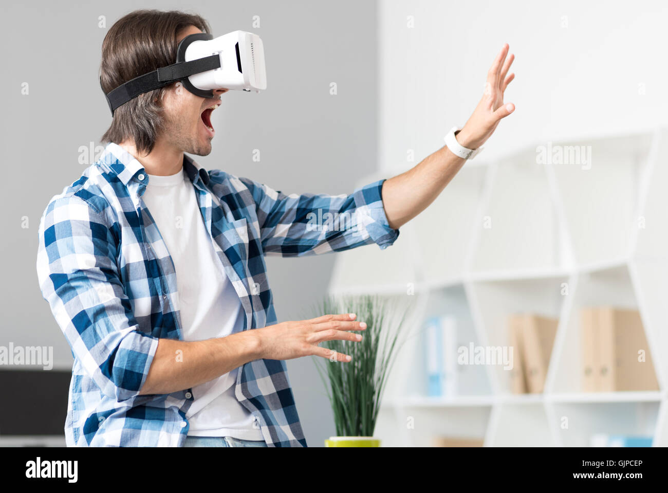 Emotional man using virtual reality device Stock Photo - Alamy