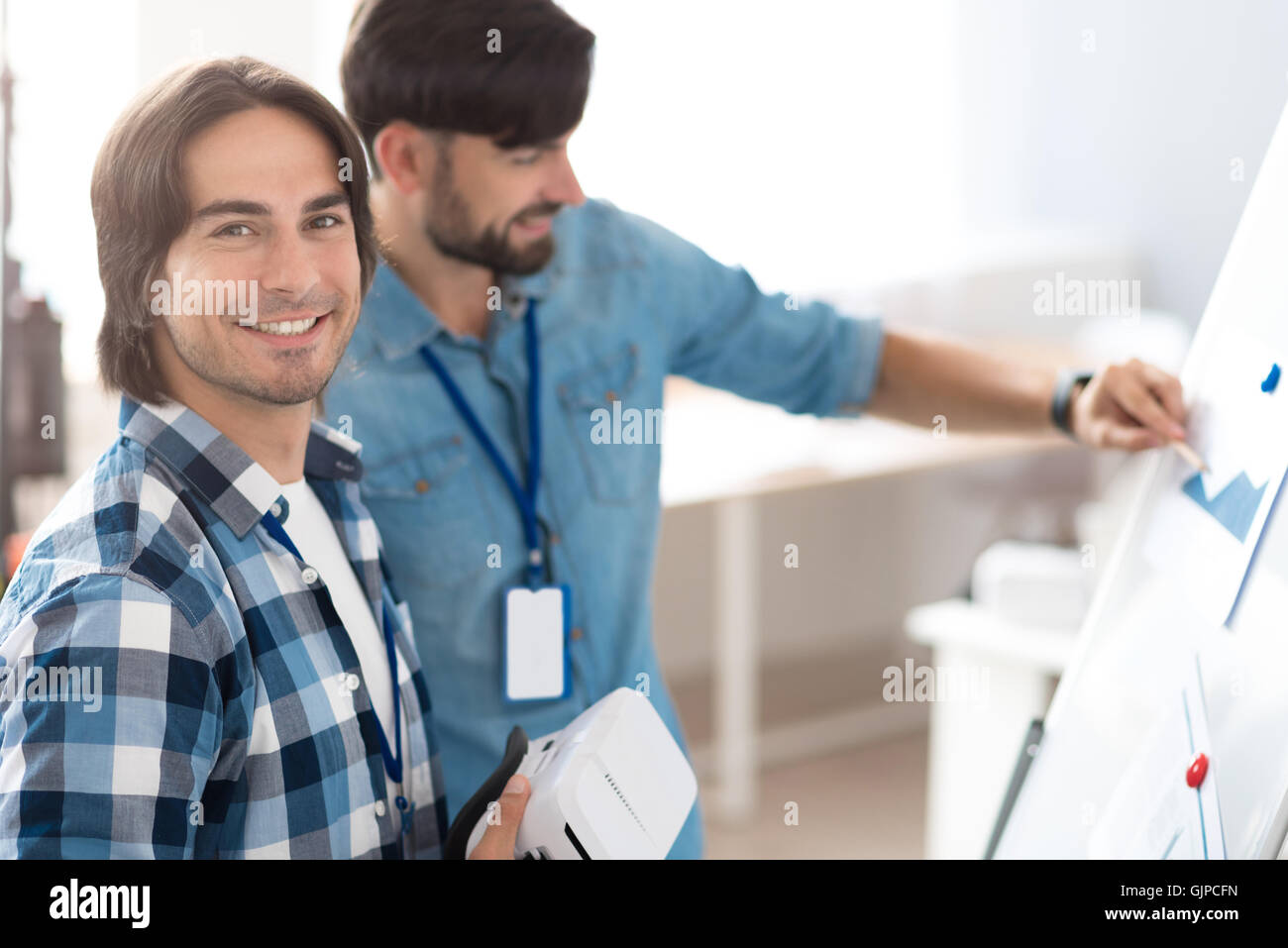 Positive man working with his colleague Stock Photo - Alamy